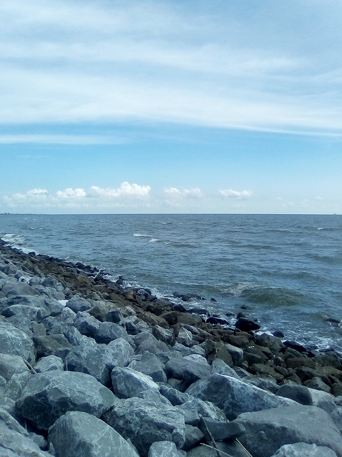 The rocky jetty meets gentle Gulf waters in a scene so peaceful you'll wonder why you ever stressed about anything.