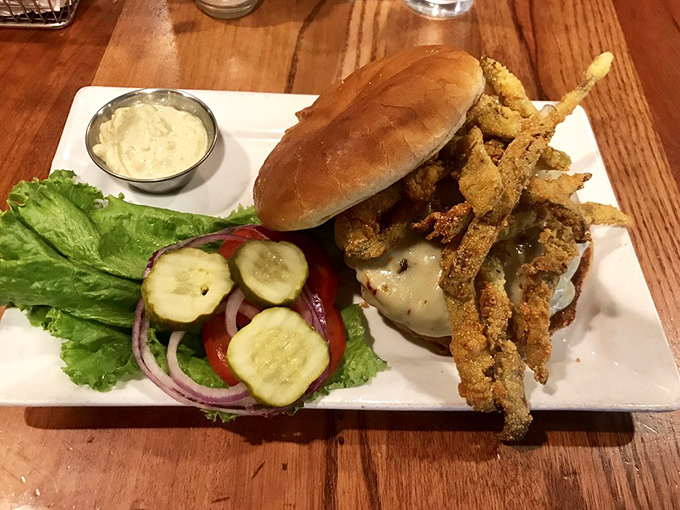 The Green Chile burger arrives with crispy onion strings standing at attention, as if they know they're part of something extraordinary.
