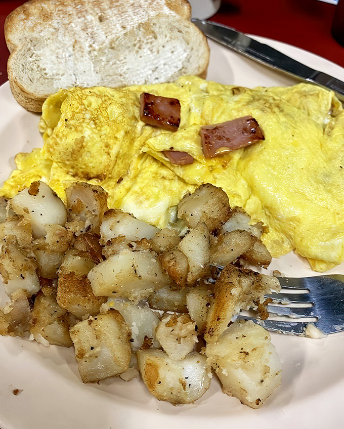 This isn't just an omelet&mdash;it's breakfast architecture. Golden eggs, perfectly crisped potatoes, and toast ready for action. The breakfast trifecta in its natural habitat.