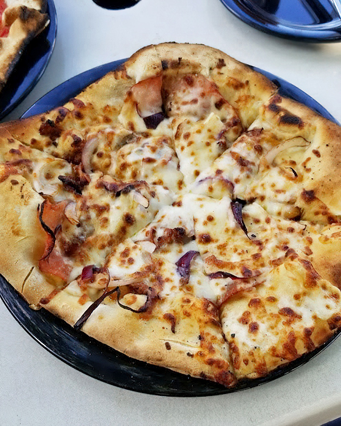 Wood-fired magic happens when simple ingredients meet intense heat. This pizza's caramelized edges tell the story of perfect temperature and timing.