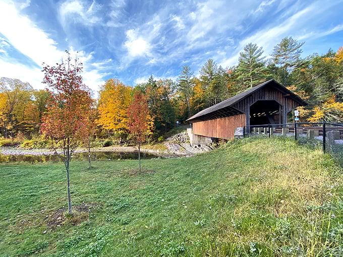 Fall foliage frames this historic covered bridge like nature's perfect Instagram filter, no hashtags or influencer poses required.