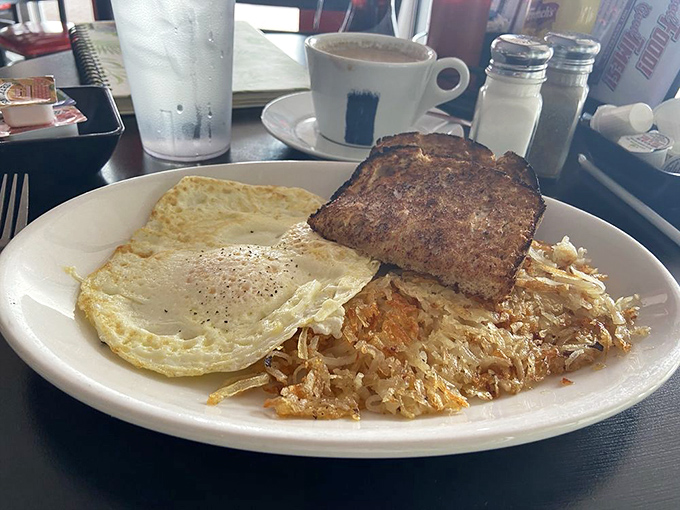 Breakfast perfection on a plate: crispy hash browns, perfectly fried eggs, and toast that somehow manages to be both buttery and sturdy enough for yolk-dipping operations.