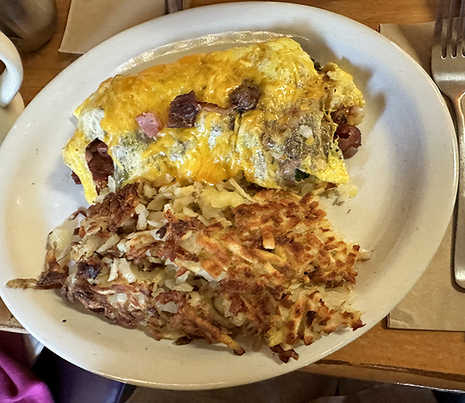 This omelet doesn't just contain ingredients; it showcases them. Paired with those gloriously golden hash browns, it's breakfast perfection on a plate.