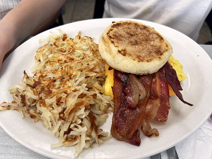 The breakfast sandwich that launched a thousand food dreams – crispy hash browns, English muffin, and bacon stacked like edible architecture.