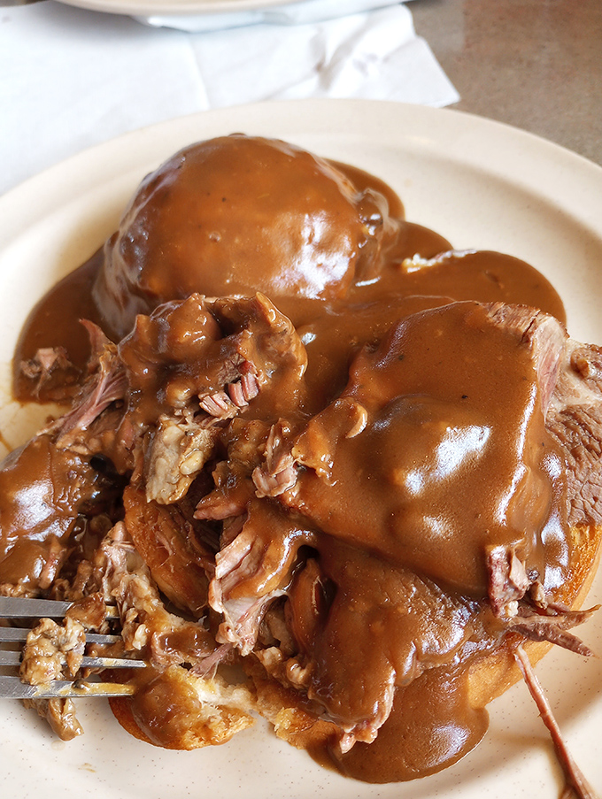 Hot beef sandwich that would make your grandmother nod in approval. This isn't food&mdash;it's a warm hug served on a white plate.