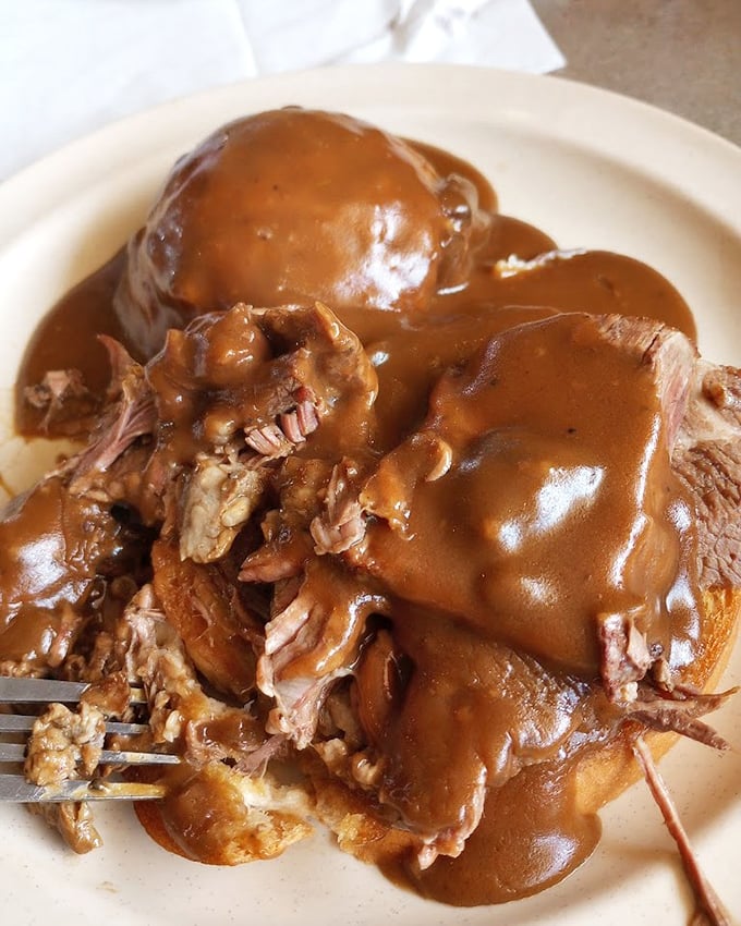 Hot beef sandwich drowning in rich gravy that would make your grandmother weep with joy. Comfort food isn't just a category here&mdash;it's a spiritual experience.