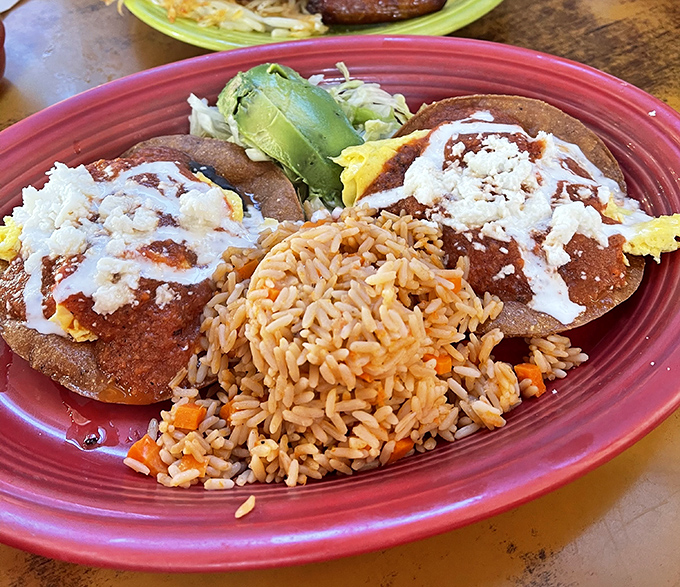 These aren't your average huevos rancheros—they're a fiesta on a plate, complete with Spanish rice and enough cheese to make Wisconsin nervous.