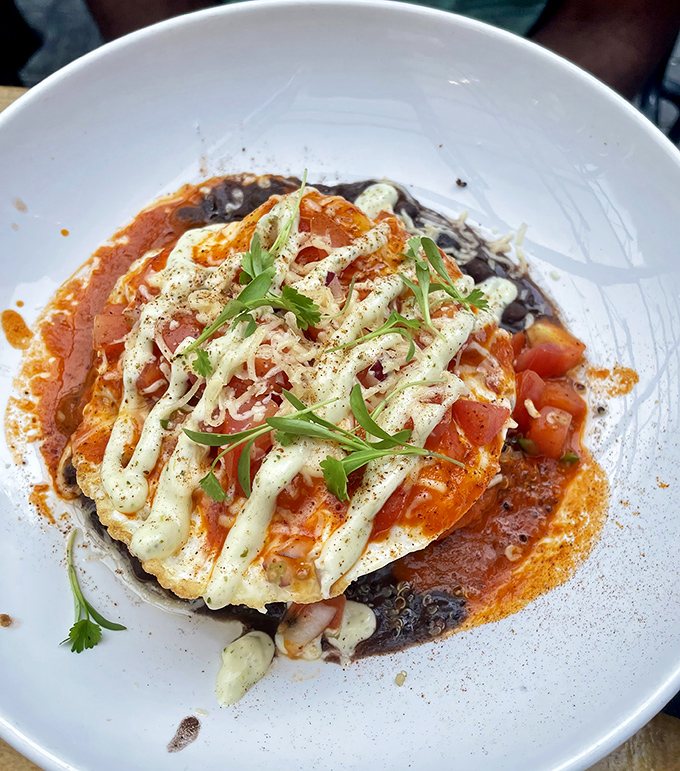 These huevos rancheros don't just break eggs, they break the sound barrier of flavor with their perfect balance of spice, cream, and that runny yolk glory.