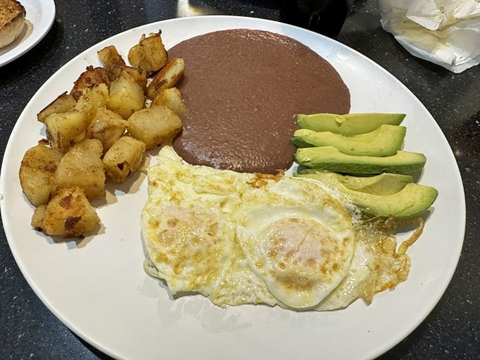 Eggs sunny-side up, crispy potatoes, and refried beans with sliced avocado&mdash;a breakfast plate that's both simple and sublime.