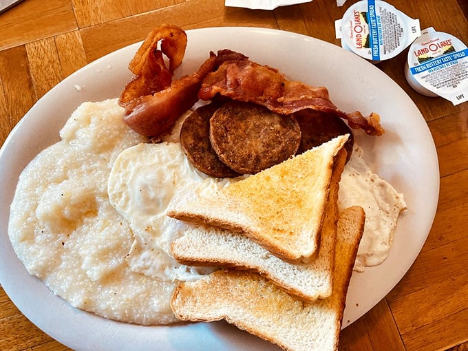 Breakfast of champions! Creamy grits, perfectly fried eggs, and bacon that would make a vegetarian question their life choices.