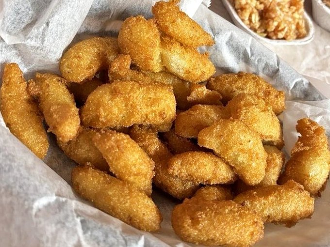 Golden-brown hush puppies that crunch like nature's perfect snack food. These crispy cornmeal delights are what potato chips dream of becoming in their next life.