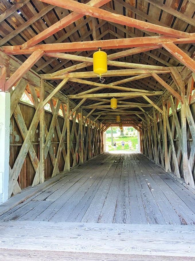 Inside, the bridge reveals its skeletal genius—a crisscross wooden lattice that's been holding up horse carriages and history for generations.