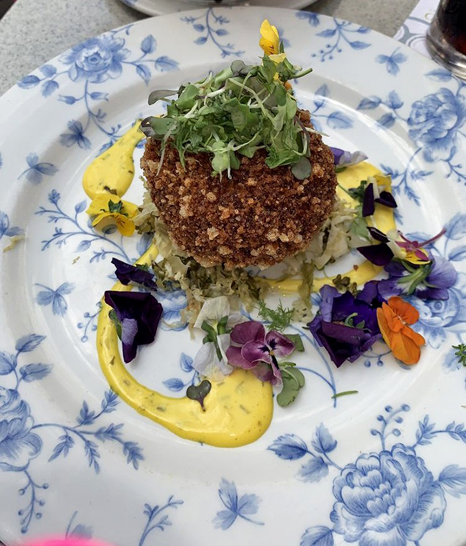 This isn't just any crab cake&mdash;it's edible art, where crispy exterior gives way to delicate seafood, all dressed up with edible flowers like it's heading to the Royal Ascot.