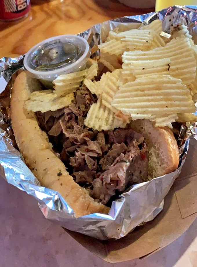 The Italian beef sandwich comes wrapped like a present, with chips standing guard. Meat this tender deserves its own security detail.