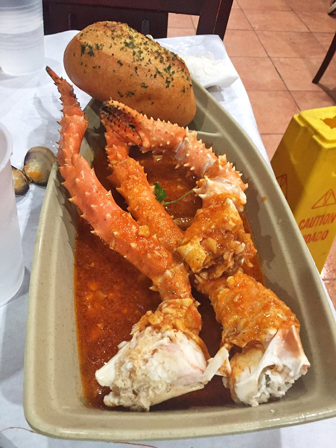 King crab legs bathed in spicy sauce with a side of garlic bread &ndash; proof that sometimes the messiest meals create the most pristine memories.