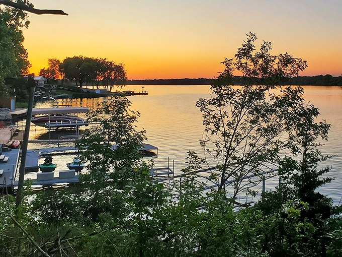 Golden hour at Lake Mitchell transforms ordinary water into liquid gold, making every sunset feel like nature's personal apology for Monday.