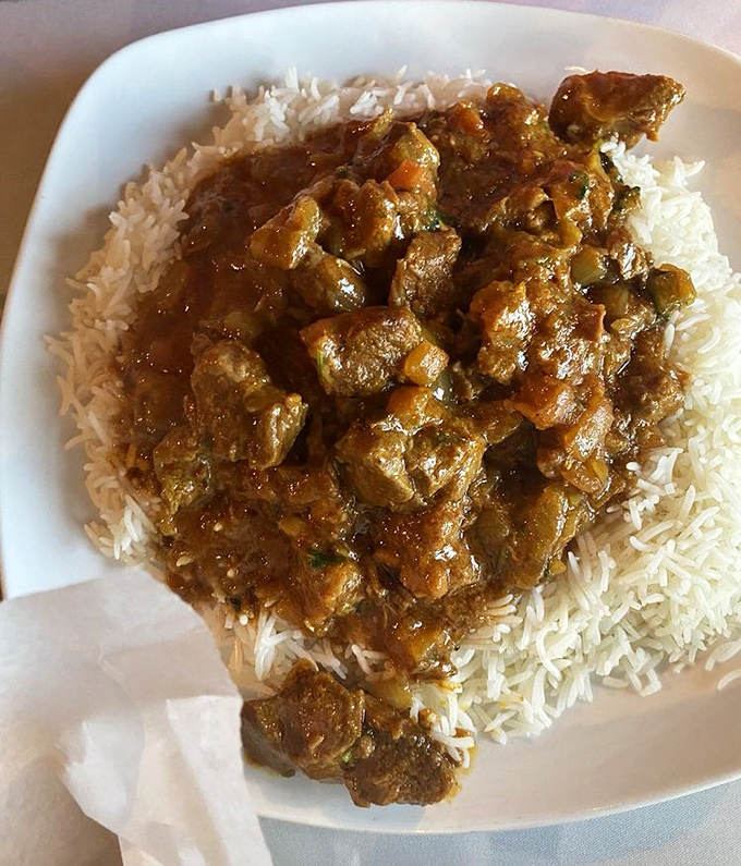 This lamb curry doesn't just sit on rice—it commands it. Each tender morsel has been simmering in that sauce long enough to write poetry.