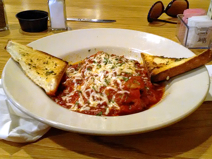 This isn't just pasta with red sauce; it's comfort in a bowl, topped with melted cheese and served with garlic bread for proper sauce-sopping.