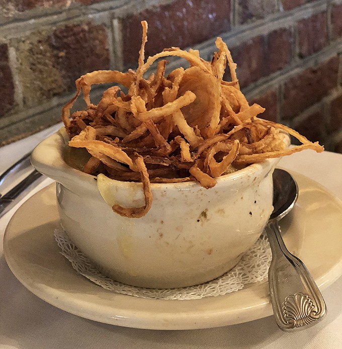 Crispy onion strings crown this soup like edible fireworks celebrating comfort food at its finest.