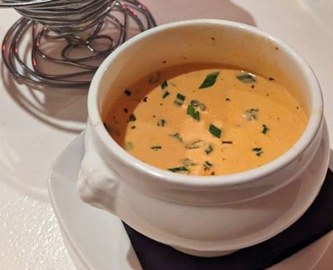 A bisque so velvety and rich it makes you wonder if lobsters secretly trained at French culinary schools before volunteering for duty.