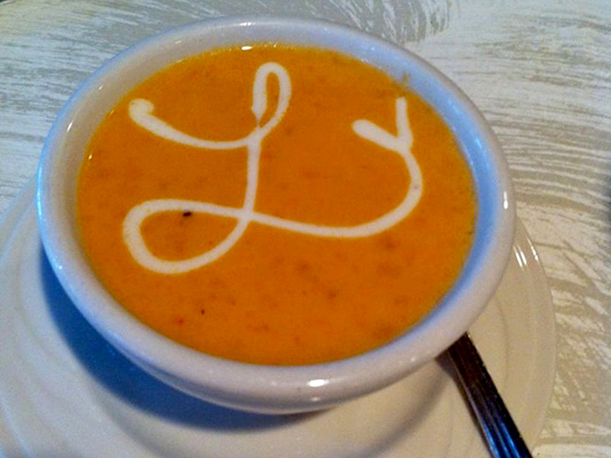 The Lobster Bisque arrives with an artistic swirl of cream, like the ocean signing its autograph on a bowl of liquid luxury.
