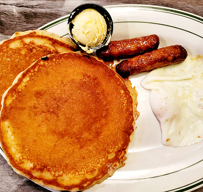 The pancake here isn't just large, it's contemplating running for office. Paired with sausage links and eggs for a breakfast democracy.