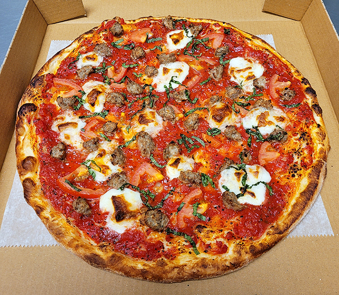 This isn't just pizza&mdash;it's a masterpiece of melted cheese, sausage, and fresh tomatoes that would make an Italian grandmother weep with joy.