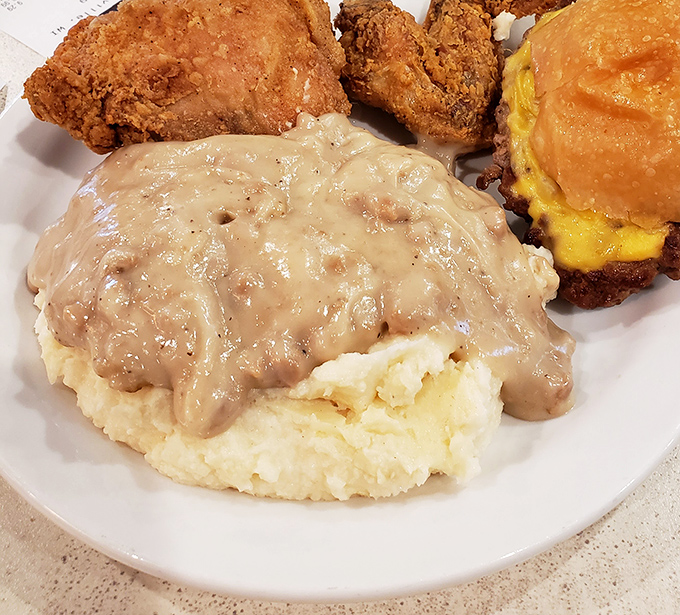 Fluffy mashed potatoes drowning in gravy alongside golden fried chicken and biscuits &ndash; comfort food that would make any grandma nod with approval.