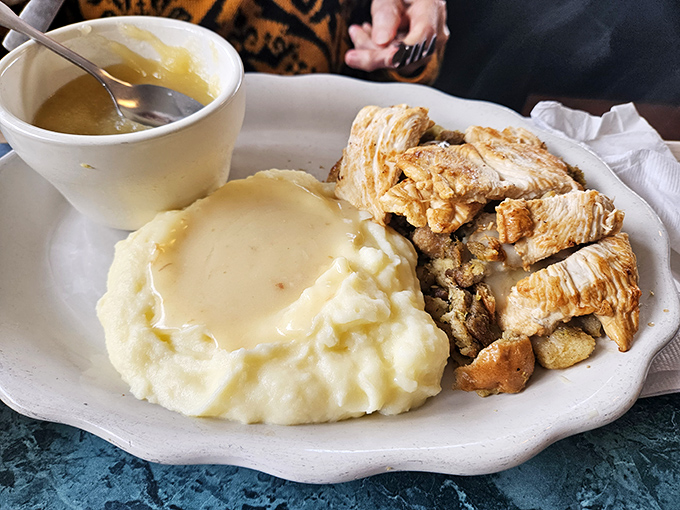 Mashed potatoes so creamy they could make a carb-counter weep, paired with perfectly tender chicken and gravy that demands to be savored.