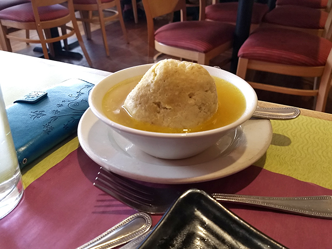 The matzo ball soup—a golden elixir cradling what might be the world's most perfect dumpling. Grandmothers everywhere would give this their tearful blessing.