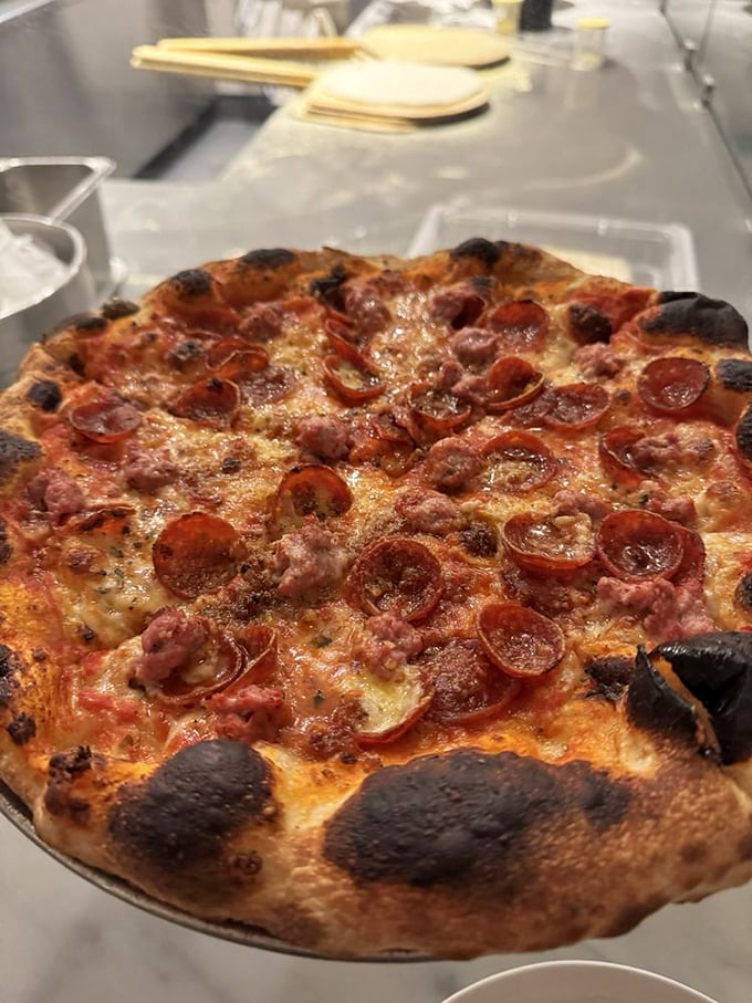 When pepperoni and sausage team up on perfectly charred crust, beautiful things happen that cameras can barely capture adequately.