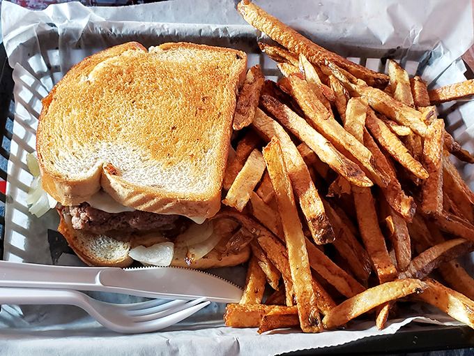 The humble patty melt—bread grilled to golden perfection, melty cheese cascading over beef—paired with fries that could make a Frenchman weep.