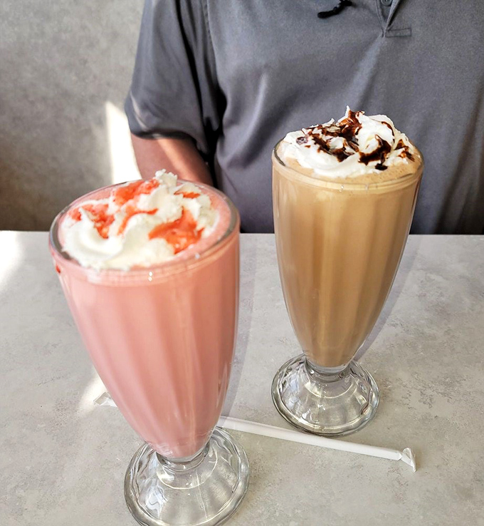 Milkshakes so thick they defy gravity—one strawberry, one chocolate, both requiring serious straw strength and zero willpower to resist.