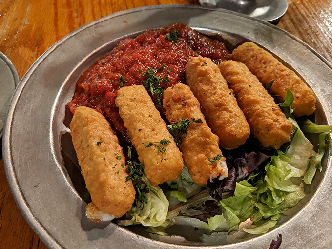 Mozzarella sticks with attitude&mdash;crispy, golden soldiers standing at attention on a bed of greens, ready to dive into that marinara battlefield.