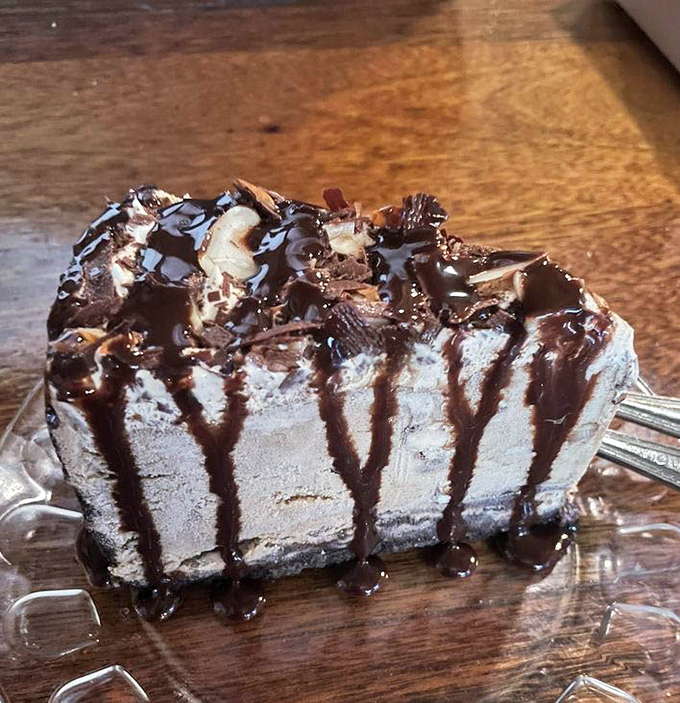 Mud pie that defies gravity and good sense. Chocolate sauce cascades down creamy layers like a decadent waterfall that's worth every extra minute on the treadmill tomorrow.