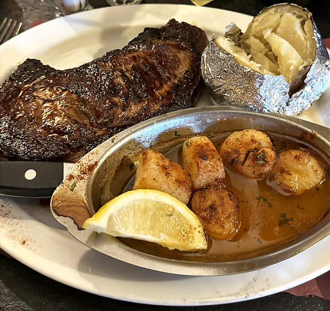 A perfectly seared New York Strip flanked by a loaded baked potato and scallops&mdash;proof that sometimes the classics never need reinvention.