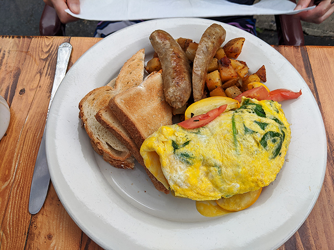 This omelet doesn't just sit on the plate&mdash;it commands attention with its perfect fold, vibrant fillings, and those home fries that deserve their own fan club.