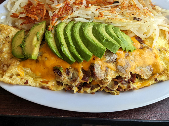 This omelet doesn't just contain avocado – it showcases it like California produce deserves, alongside perfectly melted cheese and those legendary hash browns.