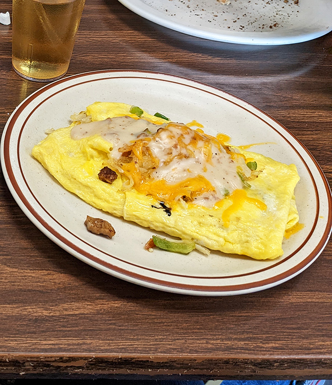 This omelet doesn't just sit on the plate&mdash;it lounges, confident in its cheesy glory. Those green peppers and bits of meat aren't ingredients; they're supporting actors in a breakfast drama.