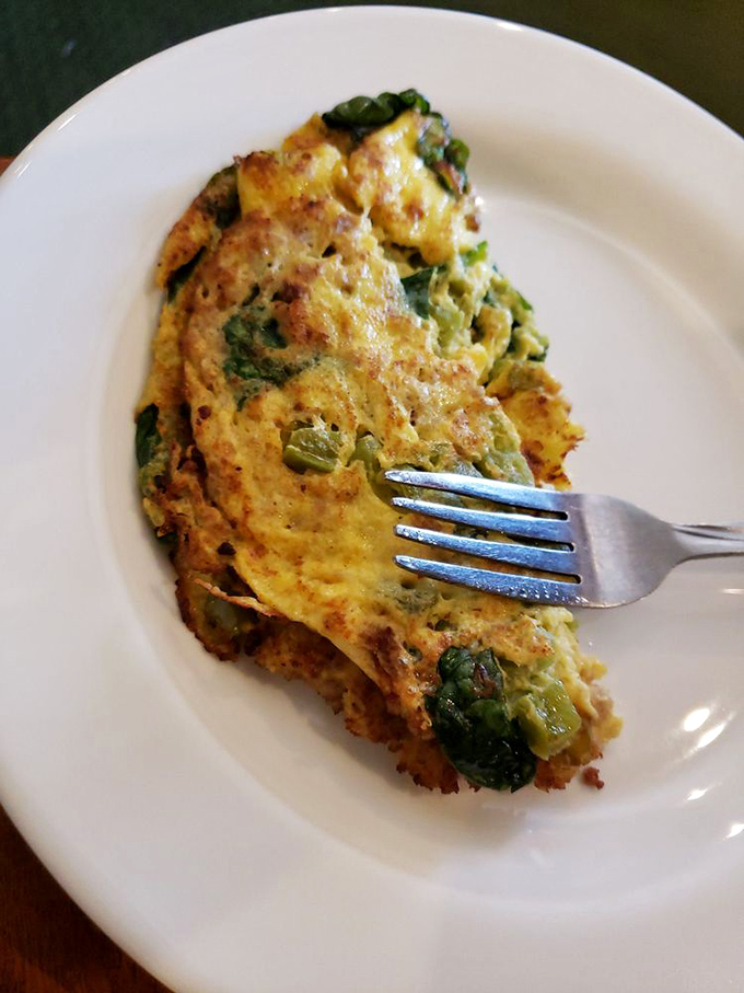 This veggie-packed omelet isn't just breakfast—it's edible art that somehow makes you feel virtuous while indulging.