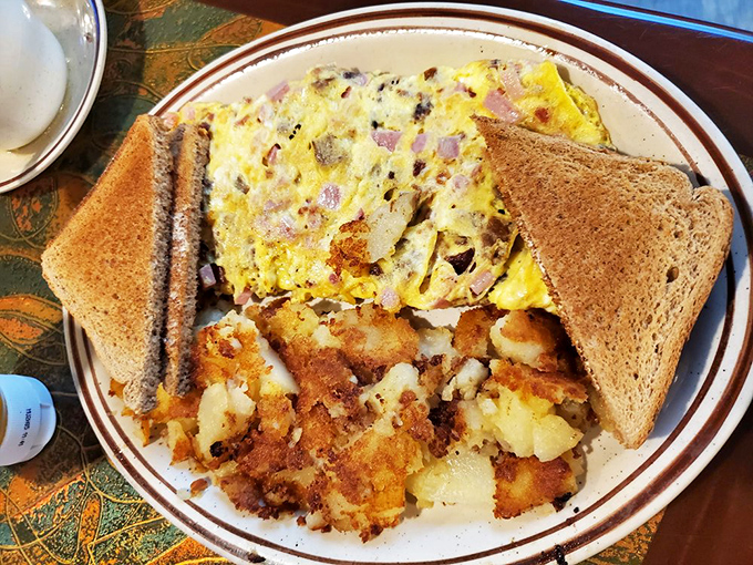 That omelet's packed tighter than a rush-hour subway car, with crispy home fries playing the perfect sidekick.