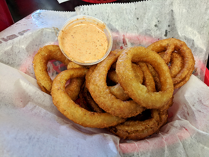 These onion rings aren't just side dishes—they're golden halos of crispy perfection with dipping sauce for baptism.