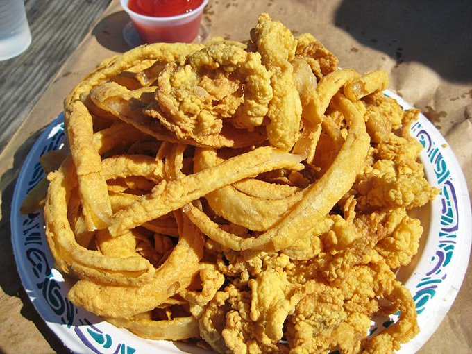 The perfect marriage: golden fried clams nestled among crispy french fries. A plate that whispers "summer in Massachusetts" with every bite.