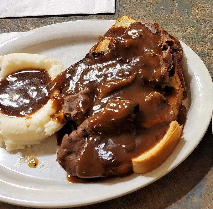 Open-faced roast beef swimming in rich gravy alongside cloud-like mashed potatoes. Grandma would approve, then ask for the recipe.