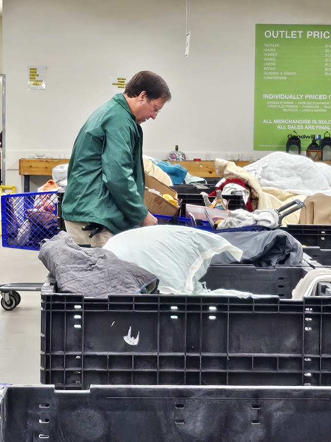 The thrill of the hunt in action. Seasoned bargain archaeologists carefully excavate through layers of possibility in the famous Goodwill bins.