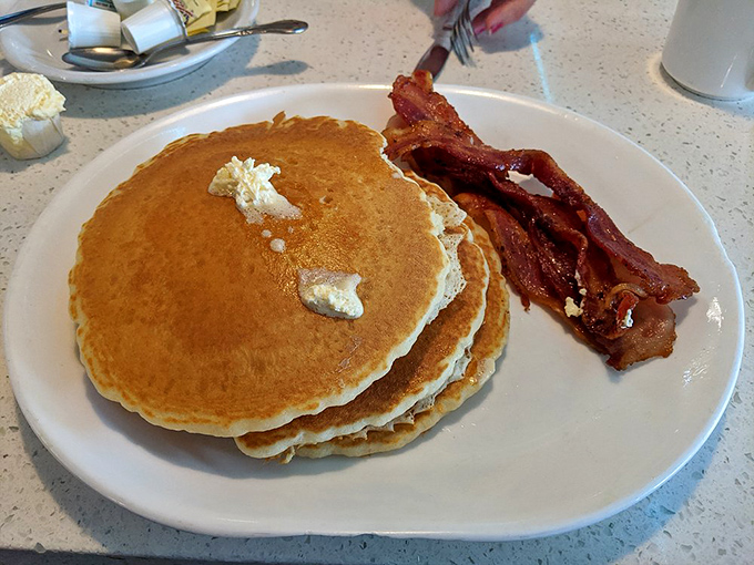 Pancakes stacked higher than your weekend plans, with butter melting like your resolve to "just have coffee."