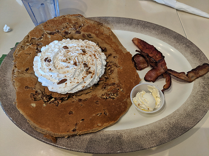 This isn't just a pancake&mdash;it's a canvas of comfort topped with a cloud of whipped cream and bacon standing guard against anyone who might try to steal a bite.