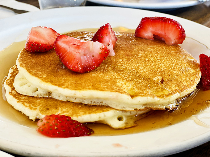 These pancakes aren't just breakfast, they're edible sunshine&mdash;golden discs of fluffy perfection crowned with strawberries that make mornings worth facing.