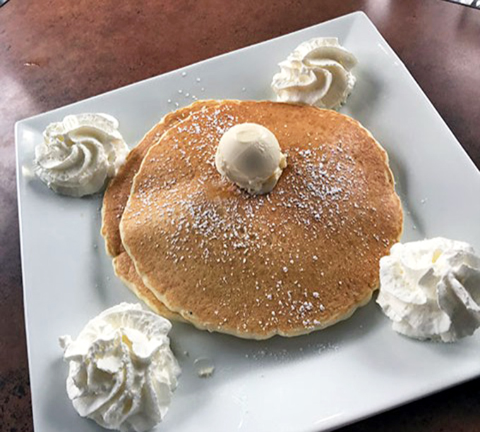 Pancake perfection isn't just about size&mdash;it's about that golden-brown exterior, the cloud-like interior, and those artful dollops of whipped cream standing guard.