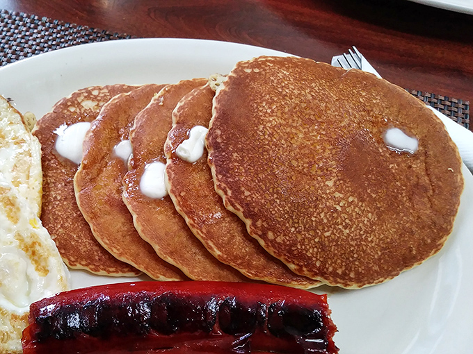 Five perfect pancakes stacked like edible architecture, each one a fluffy testament to the power of proper breakfast food.